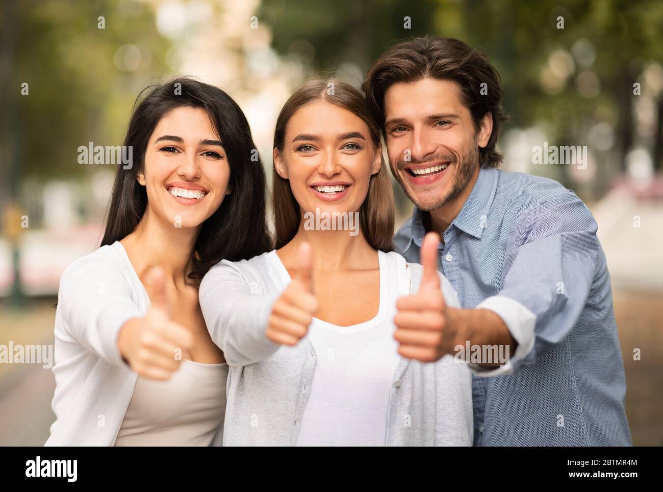 Three Happy Friends Gesturing Thumbs Up Standing Outdoor Stock Photo ...