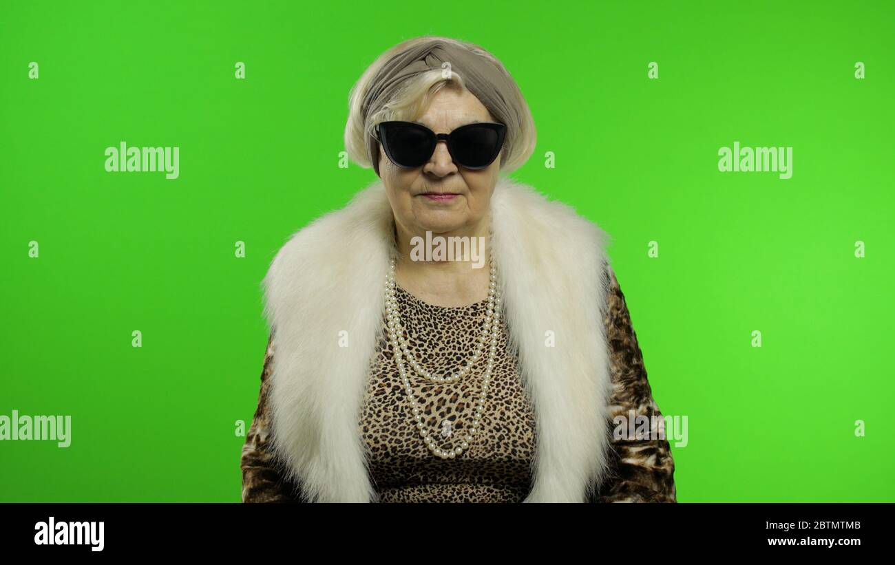 Elderly style granny caucasian woman in sunglasses posing on chroma key ...