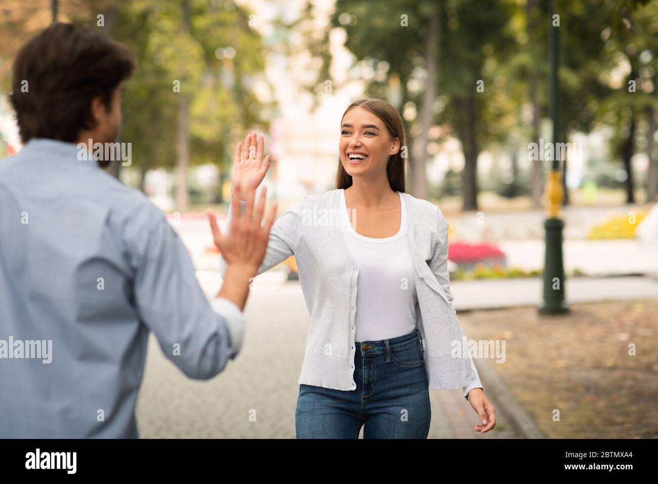 Two People Waving To Each Other