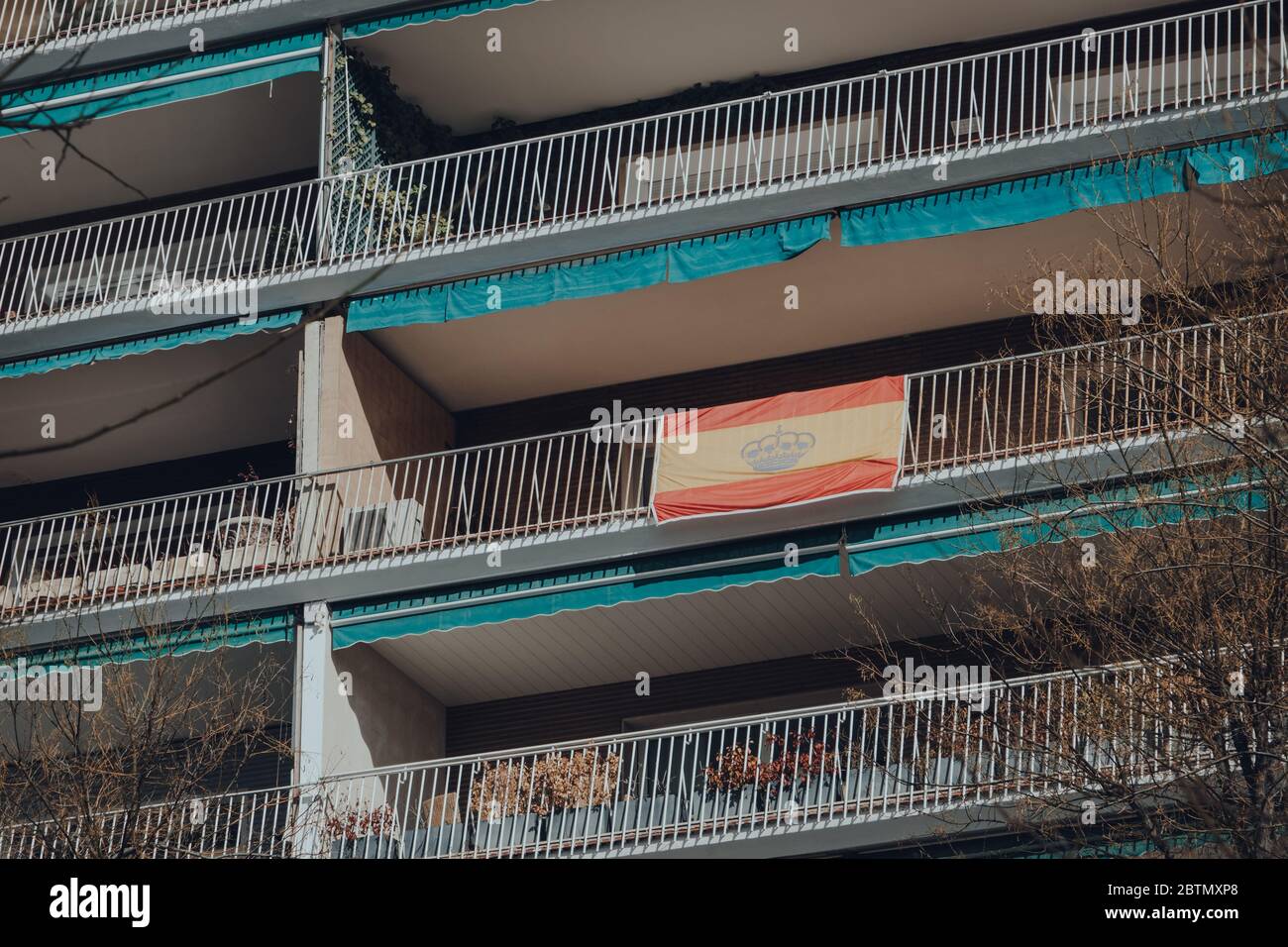 Spanish flag handing on balcony railings of a building in Madrid, Spain ...