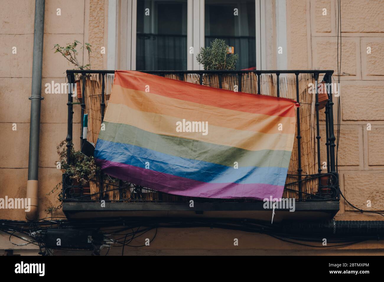 Rainbow flag handing on balcony railings of a building in Madrid, Spain ...