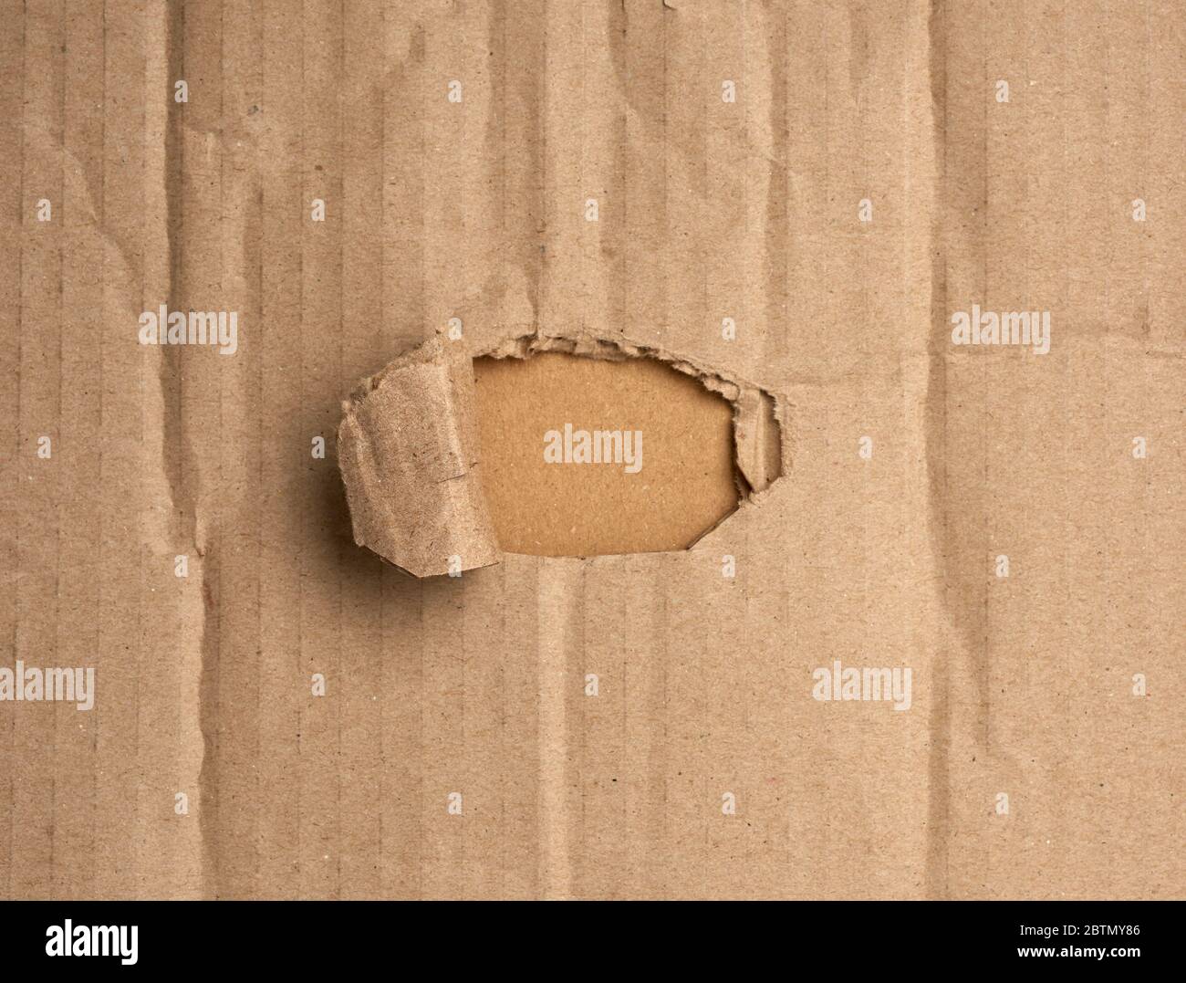 hole in brown cardboard paper with torn and curved edges, template ...