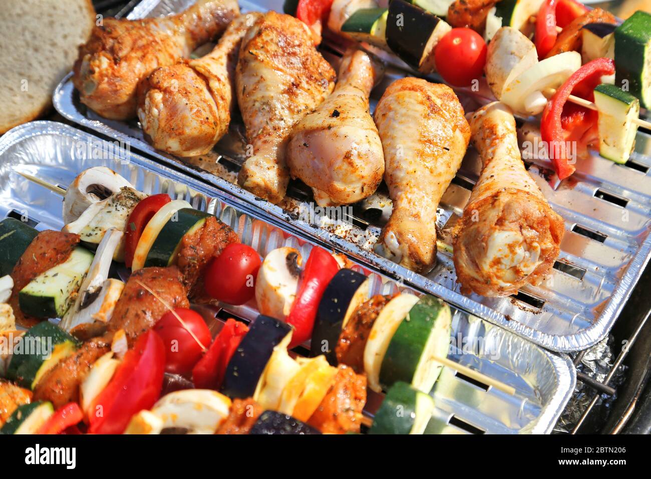 Chicken legs and vegetable skewers grilled on barbecue Stock Photo - Alamy