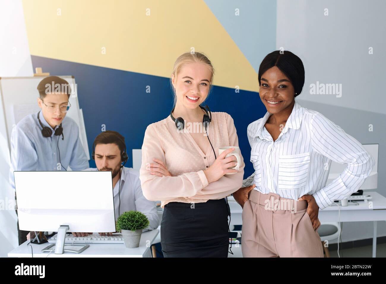 Happy service desk consultants with their colleagues at modern open ...