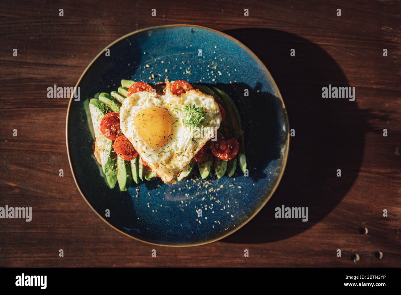 Heart-shaped fried egg on fresh avocado pear Stock Photo - Alamy