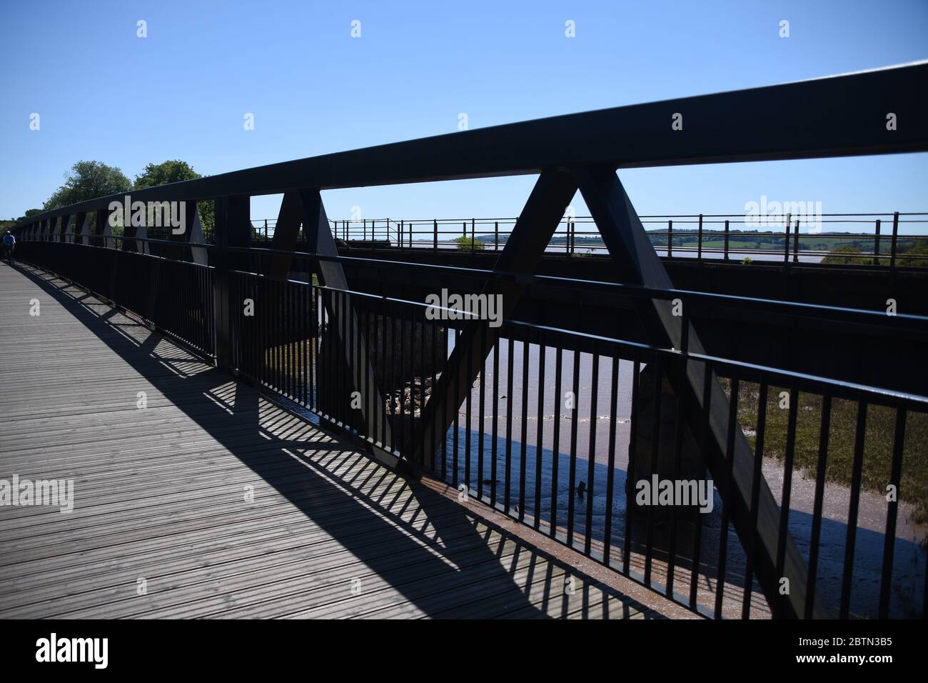 Bridge over water disappearing into distance Stock Photo - Alamy