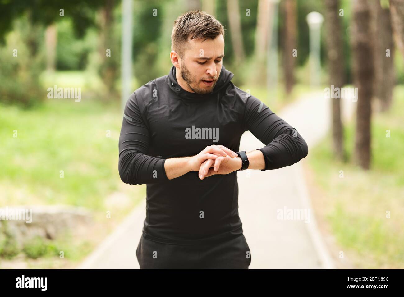 Man Running Checking Activity Tracker On Wrist Watch Stock Photo - Alamy