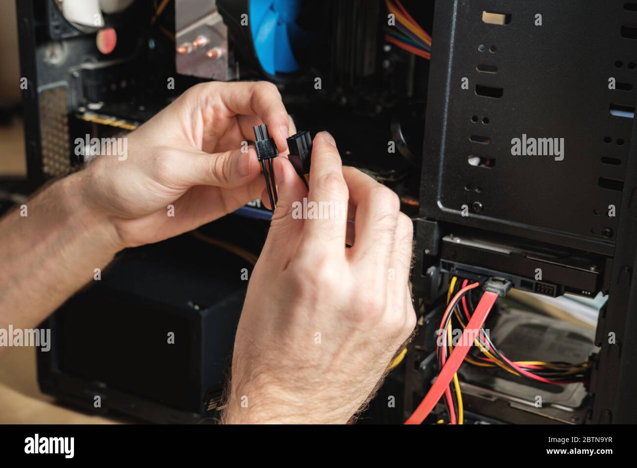 Man repairs a computer system unit, changes parts, video card and hard ...