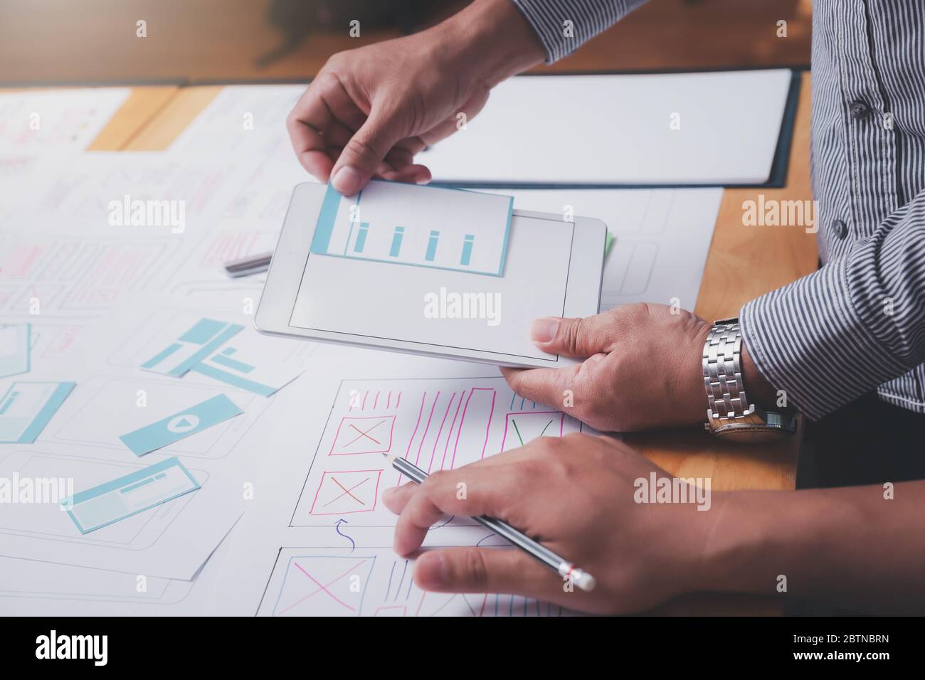 UX or UI designers designing on their smartphone application layout ...