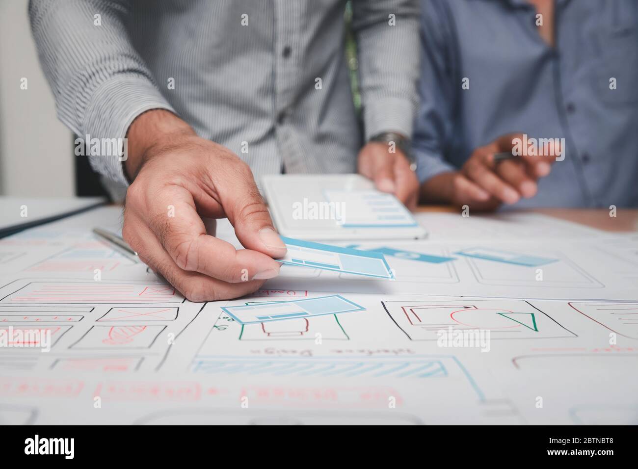 UX or UI designers designing on their smartphone application layout ...