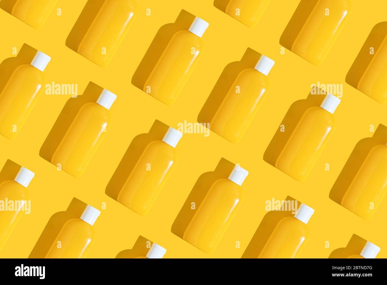 Pattern of yellow tubes of sunscreen on bright yellow background with ...