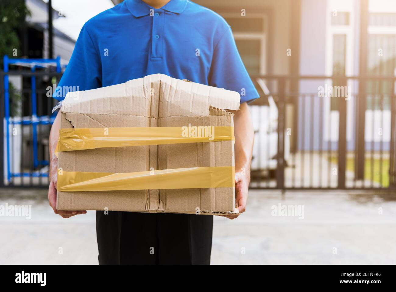 Asian young delivery man in blue uniform he emotional falling courier ...