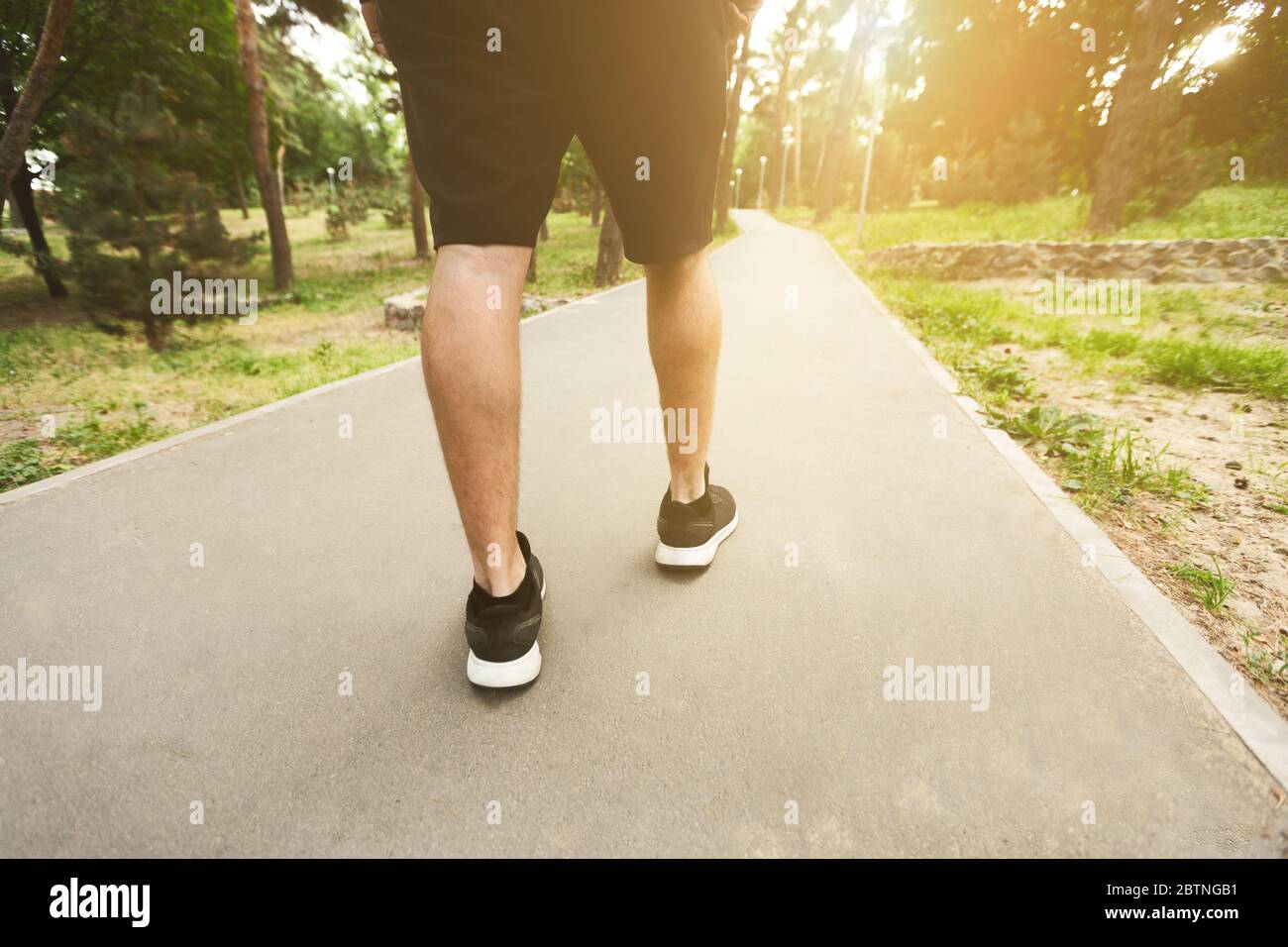 Man running walking in the park, back view of legs Stock Photo - Alamy
