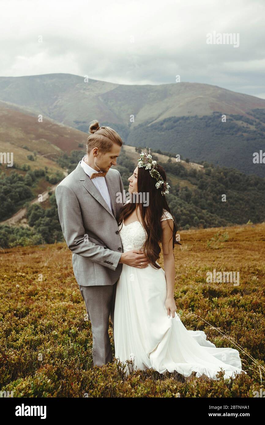 gorgeous bride and stylish groom posing hugging, boho wedding couple ...