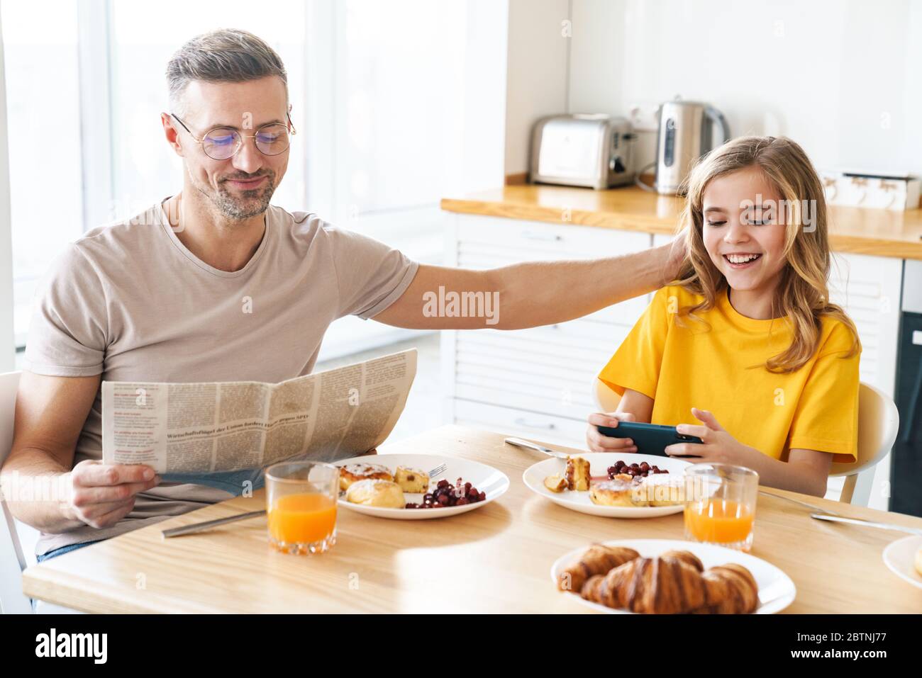 Photo of funny caucasian father and daughter using cellphone and ...