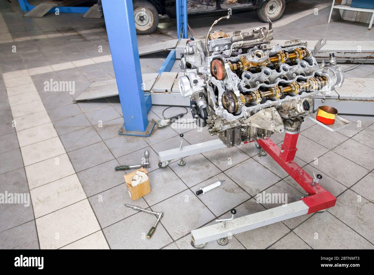 An iron large engine shot with eight cylinders on a special red stand ...