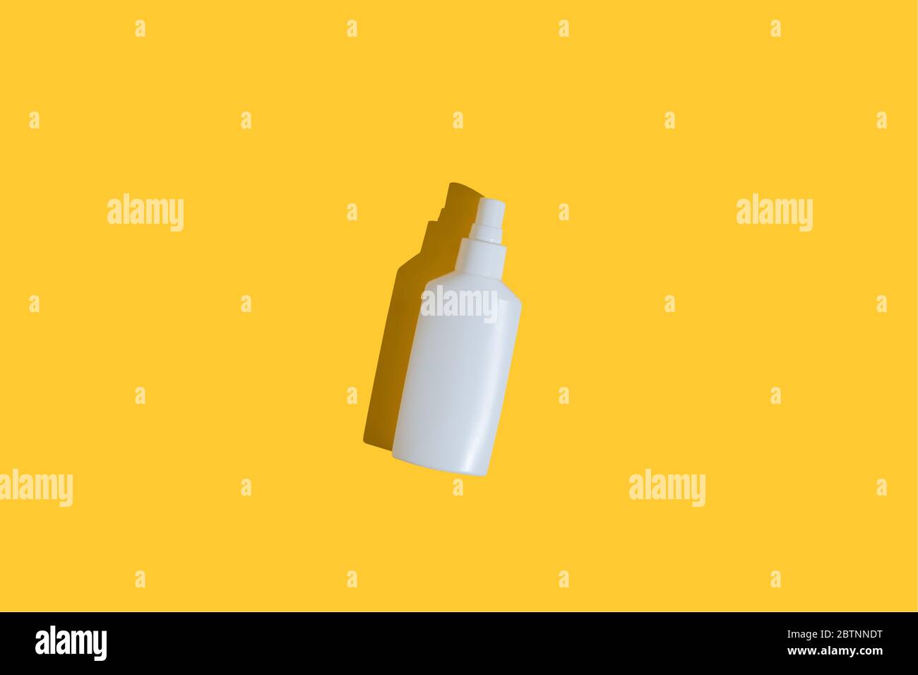 Yellow tube of sunscreen on a bright yellow background with hard shadow ...