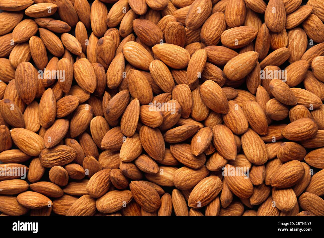 Almonds pile background Stock Photo - Alamy