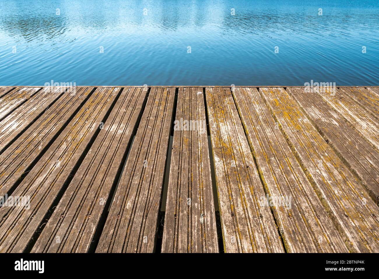 The texture of the boards of the old rustic wooden jetty on a tranquil ...