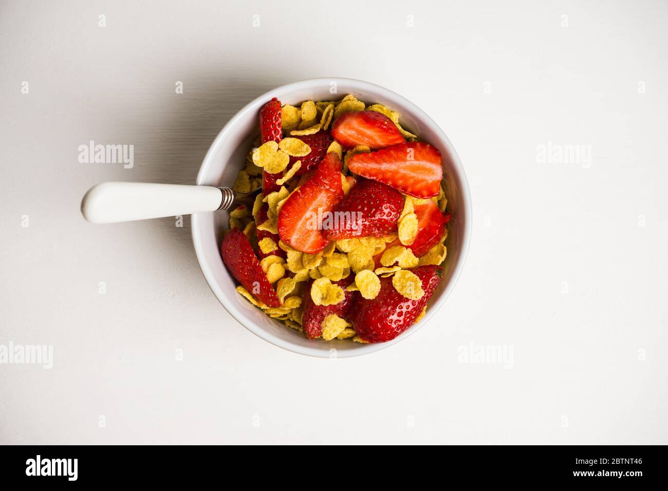 Corn flakes with fresh strawberry in bowl on the rustic background ...