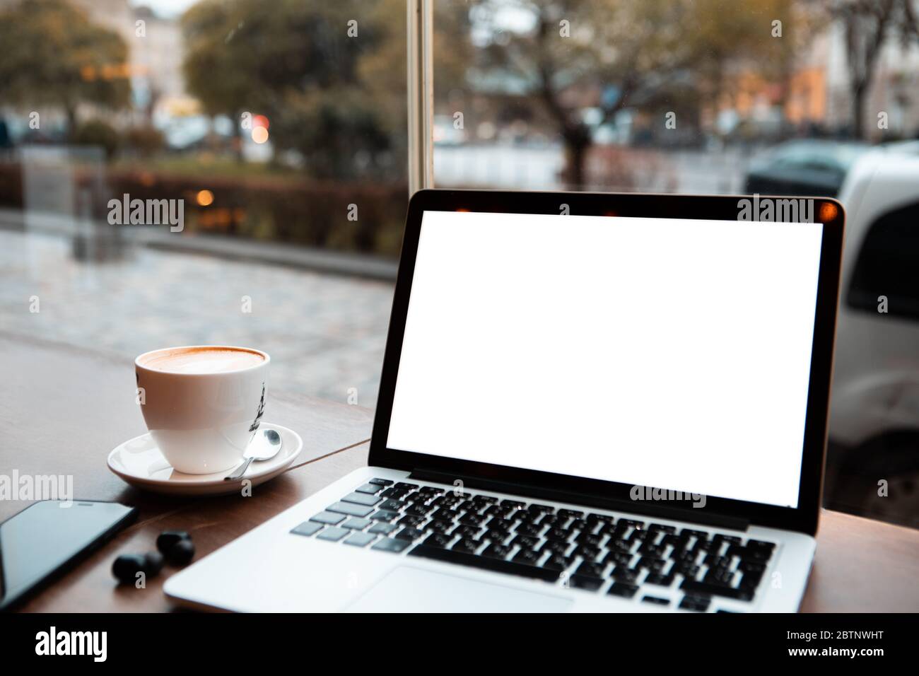 laptop with white screen in cafe table near window Stock Photo - Alamy