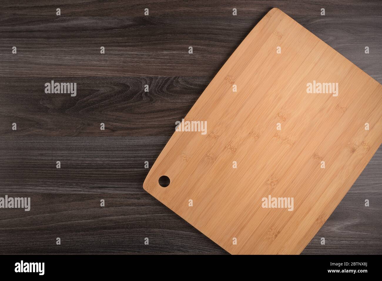 Top view of wooden cutting board on old dark wood countertop Stock ...