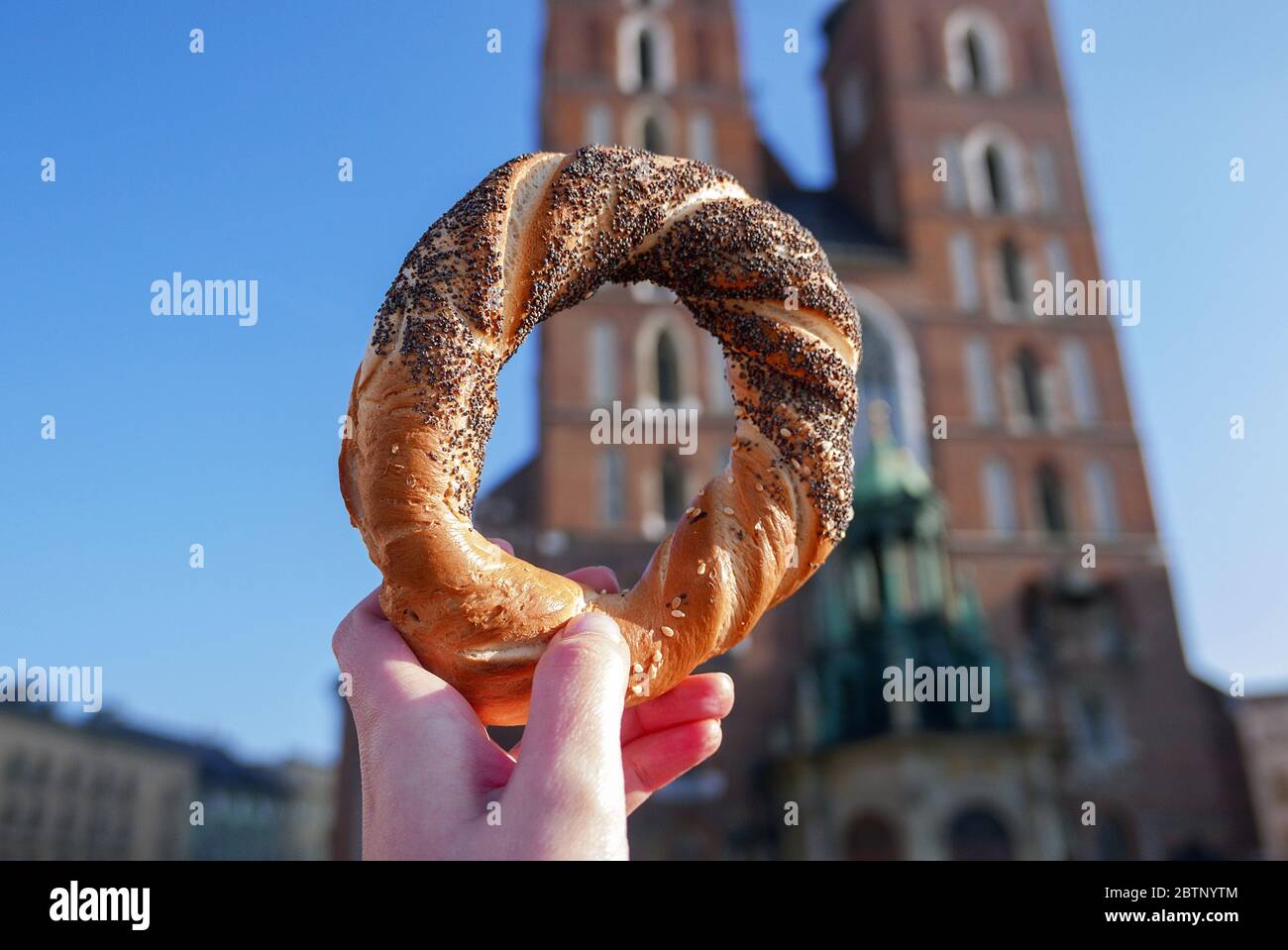 Holding bagel / obwarzanek, traditional polish snack on the Mariacka ...
