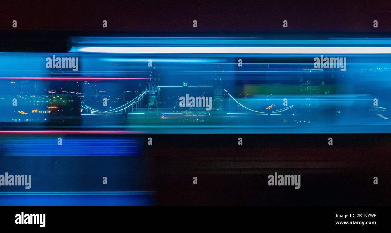 Tower Bridge at night, framed between the motion blue of a fast moving ...