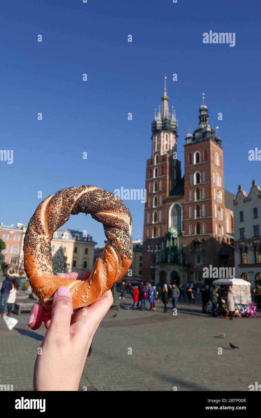 Holding bagel / obwarzanek, traditional polish snack on the Mariacka ...