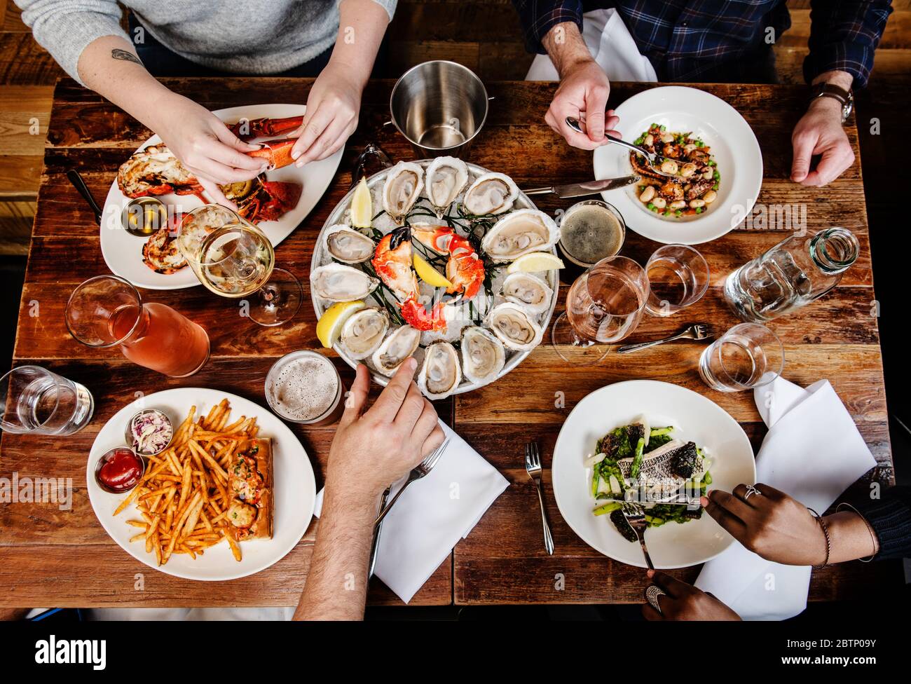 group of friends eating dinner at a seafood restaurant Stock Photo - Alamy