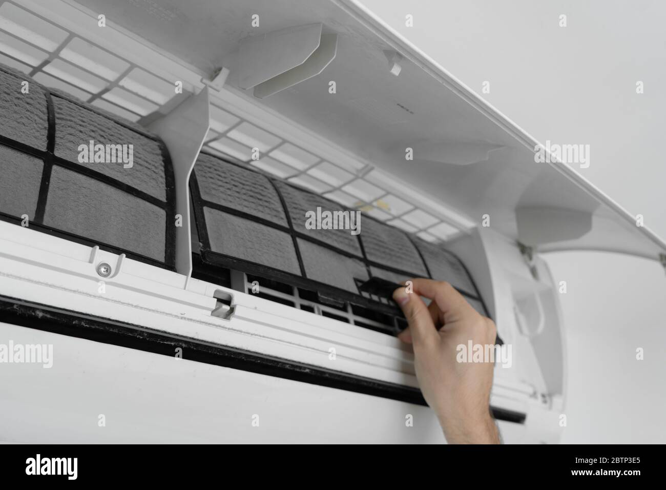 The guy cleans the filter of the home air conditioner from dust. Very ...