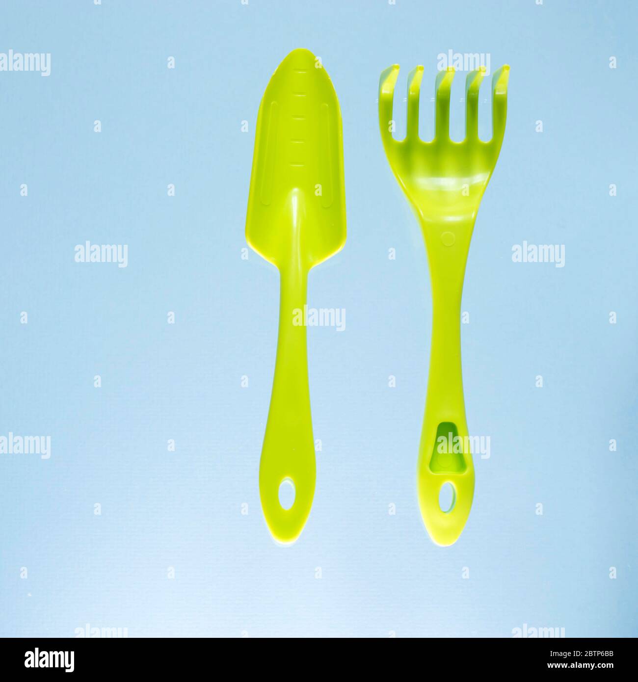 Garden set: plastic green shovel and rake for workingon the blue ...