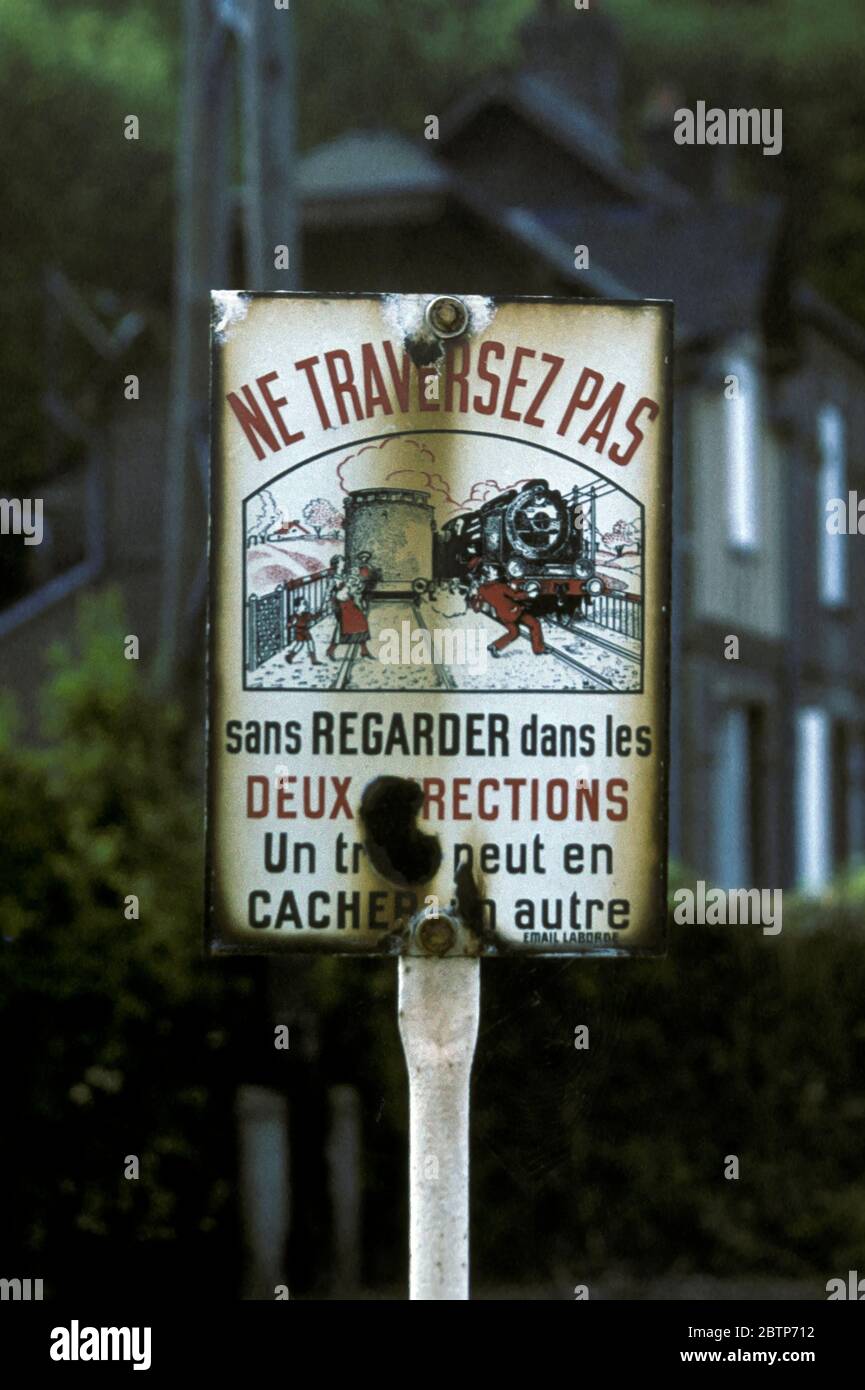 Train level crossing warning sign advising not to cross line without ...