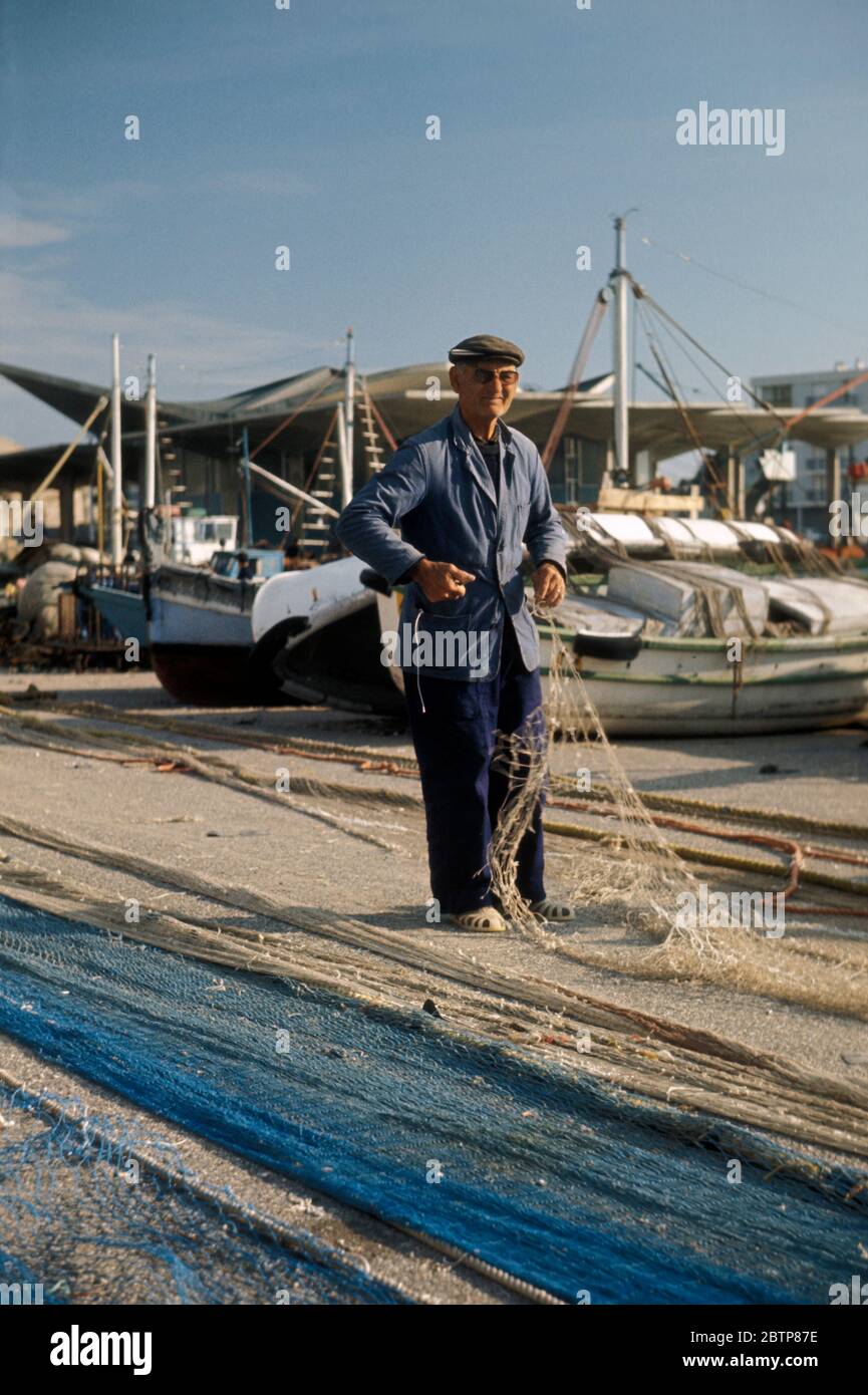 Fisherman repairing a fishing net in the old harbour of Marseille in ...