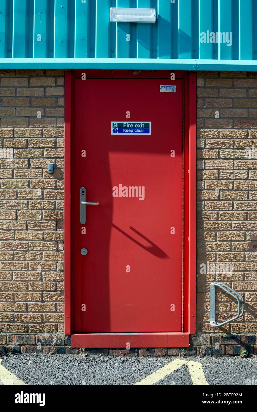 A red fire exit door on a small factory, Warwick, UK Stock Photo - Alamy