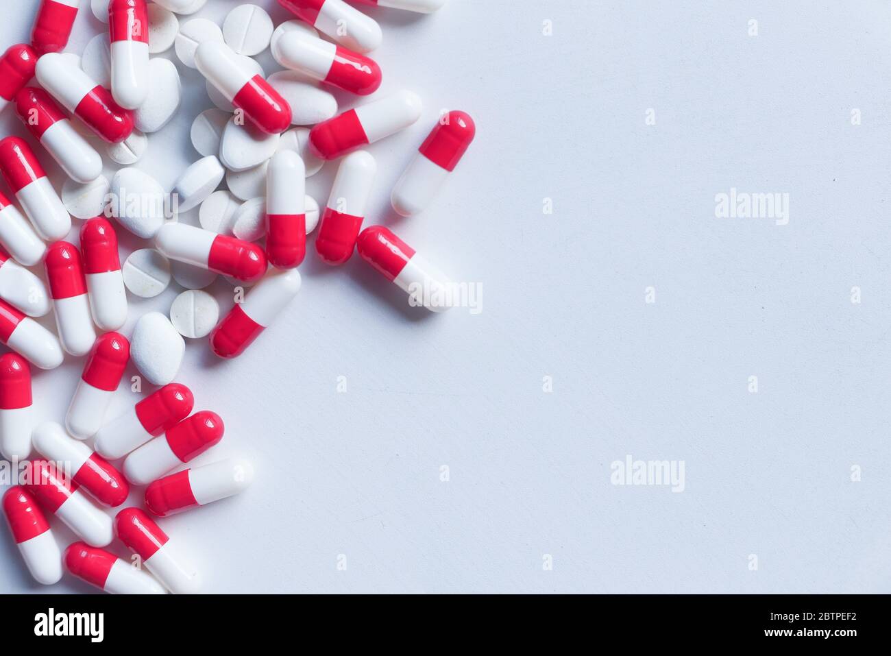 white and red capsule spilling on white background with copy space ...