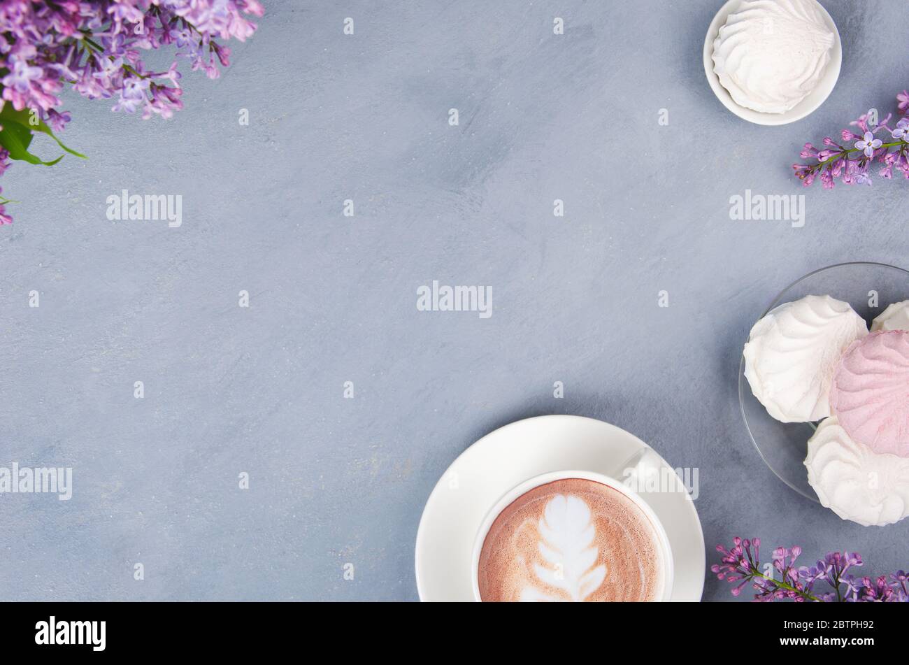 Lilac, coffee with latte art and marshmallows on gray table. Romantic ...