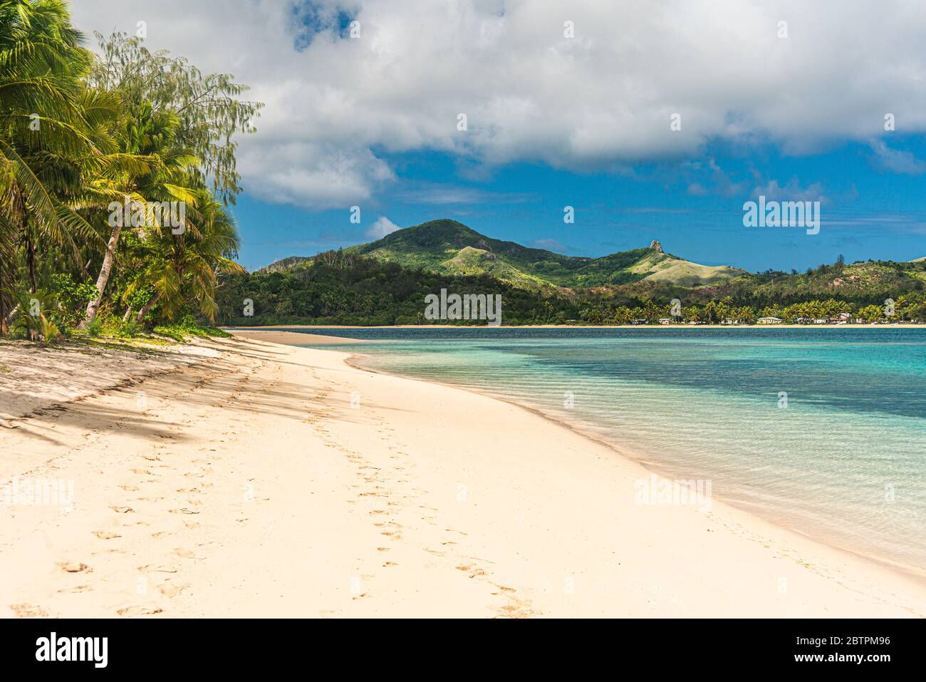 Endless white sandy beach with a tropical forest to the left. Clear ...