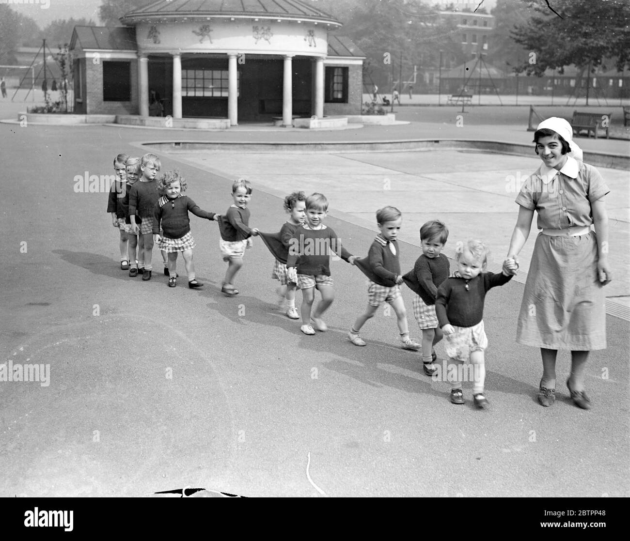 Following their leader. A game of 'trains' with nurse as the ...