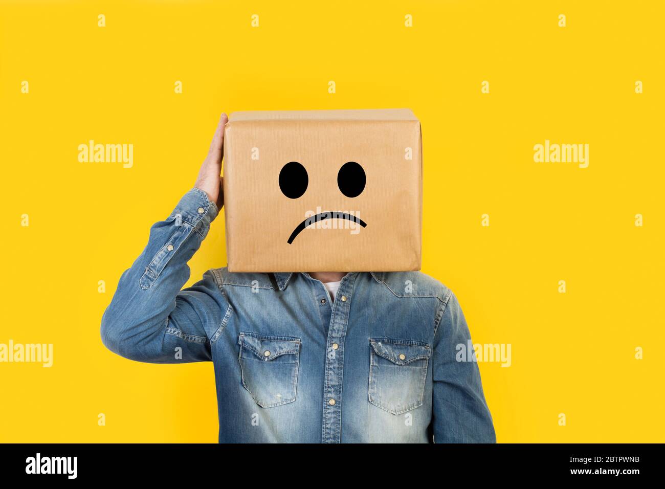 Man with his head in a box and sadness gesture drawn on it and on a ...