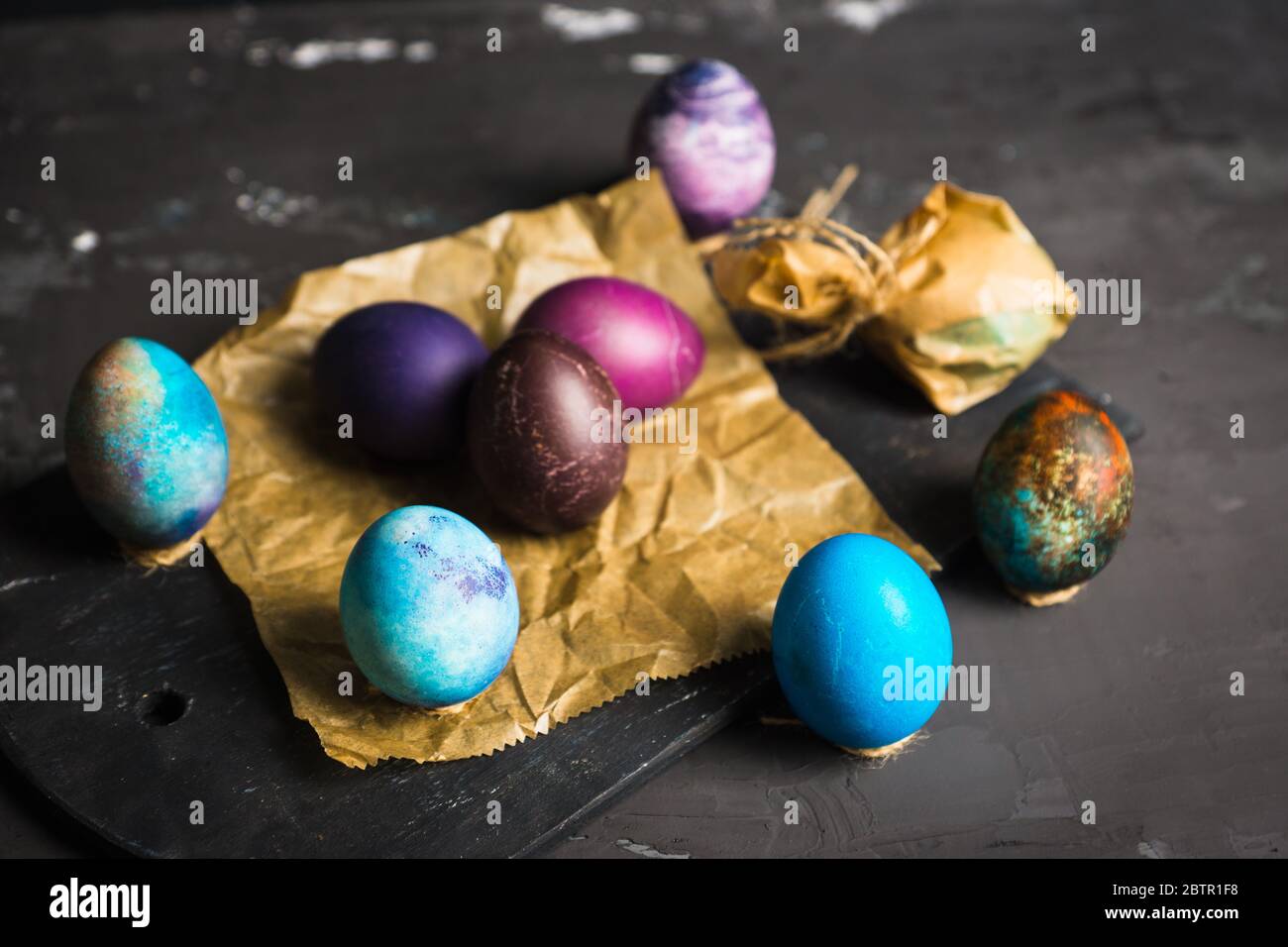 Rustic colored easter eggs on the dark stone background. Shallow depth ...