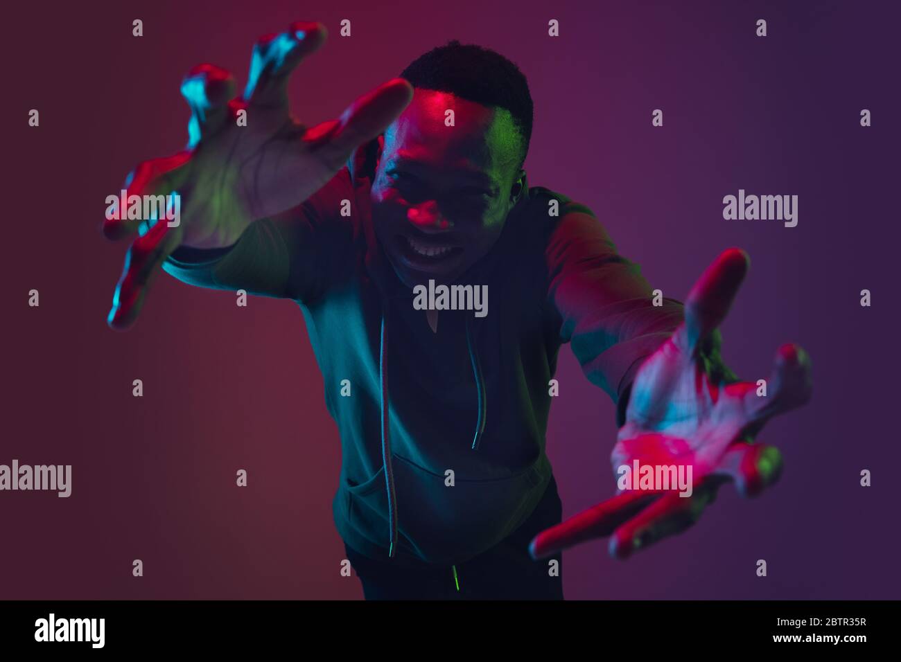 Scare taking camera, pulling hands. African-american man's portrait ...