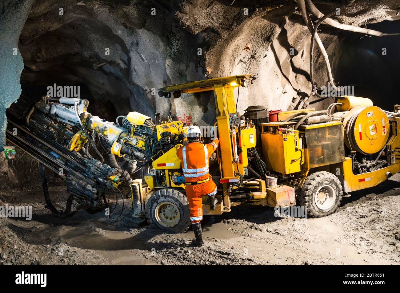 Miner climbing on a mineral mining machine Stock Photo - Alamy