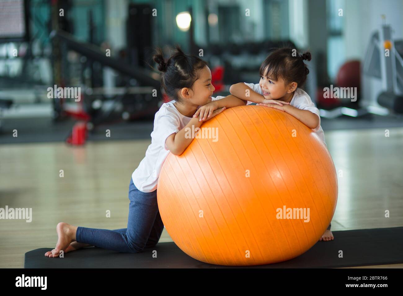 Gymnastic balls and kids on them Stock Photo - Alamy