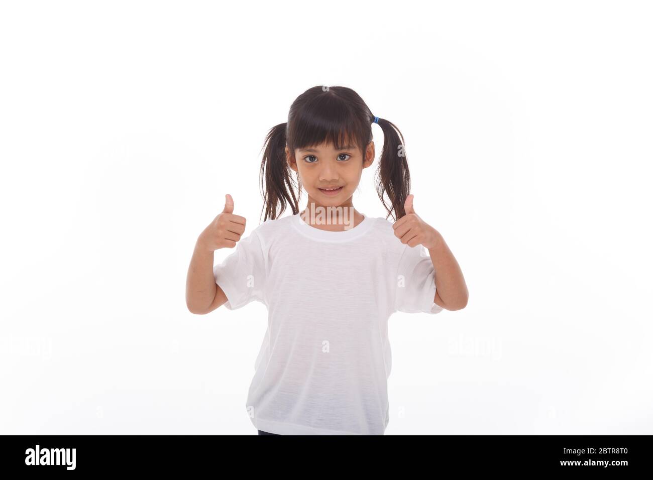 Little asian girl wearing mask for protect pm2.5 and show thumbs up gesture for good air outdoor ...