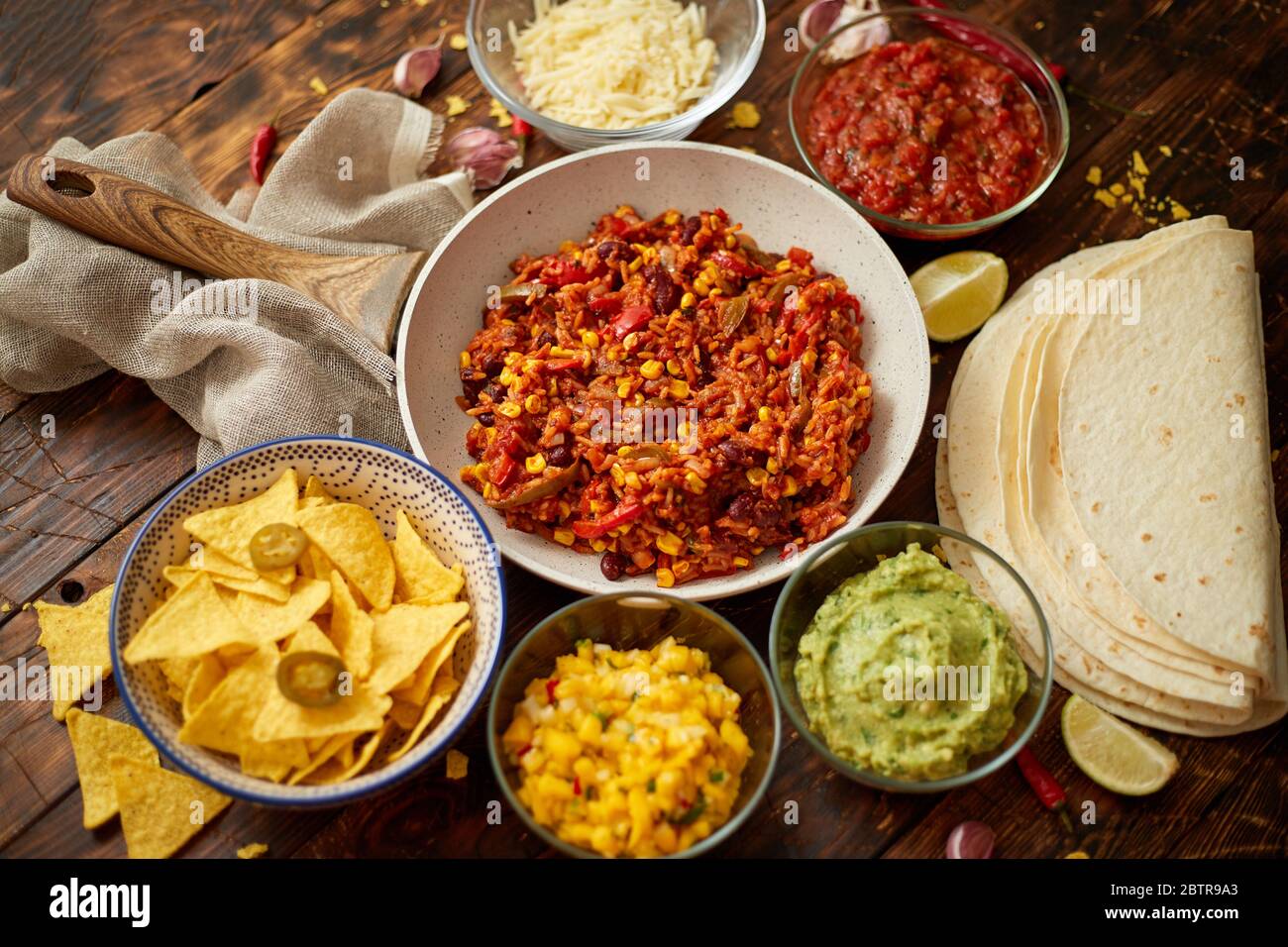 Preparing vegetable burritos on white pan. With various ingredinets for ...