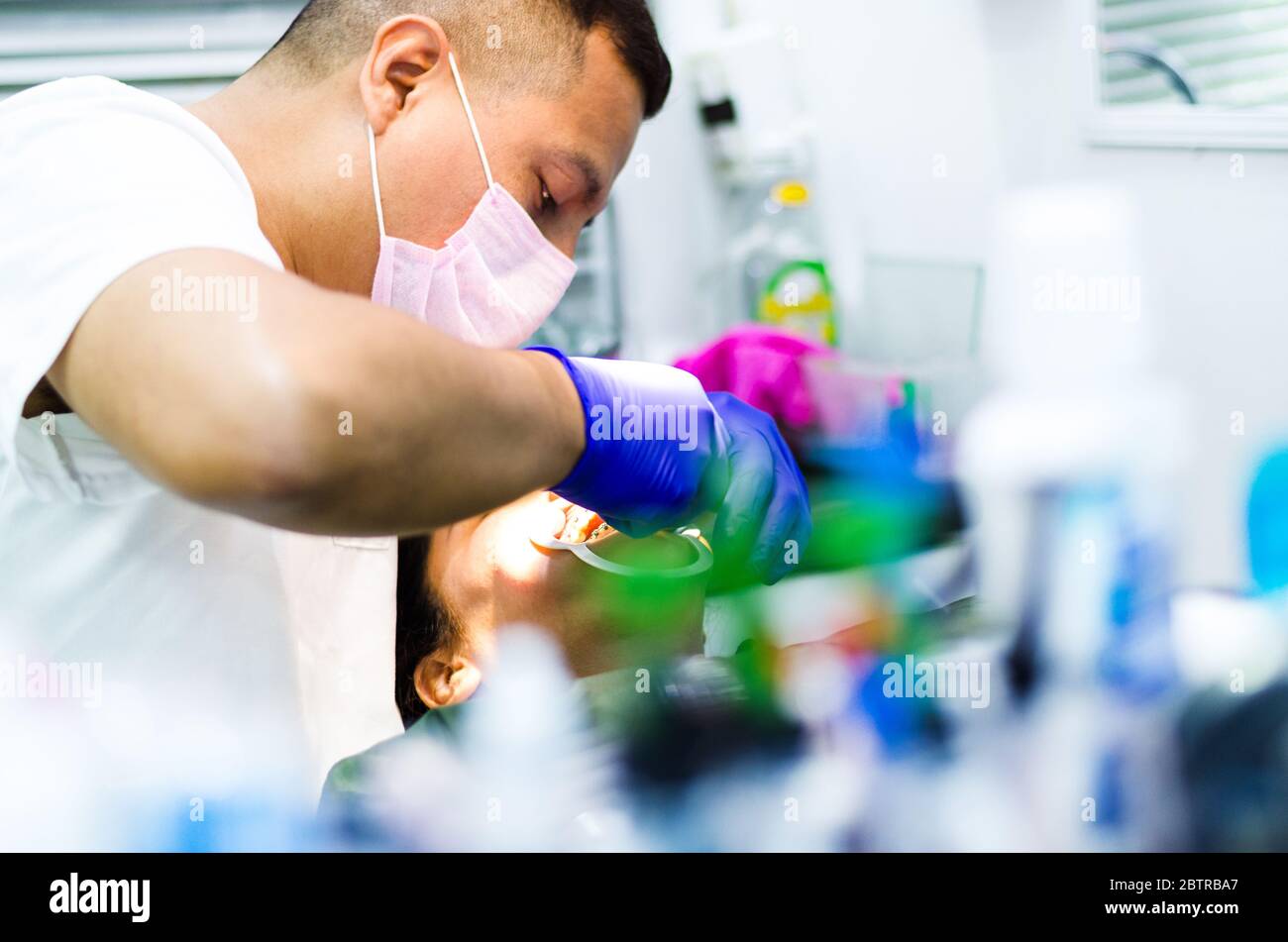 Male doctor performing extraction procedure with forceps removing ...