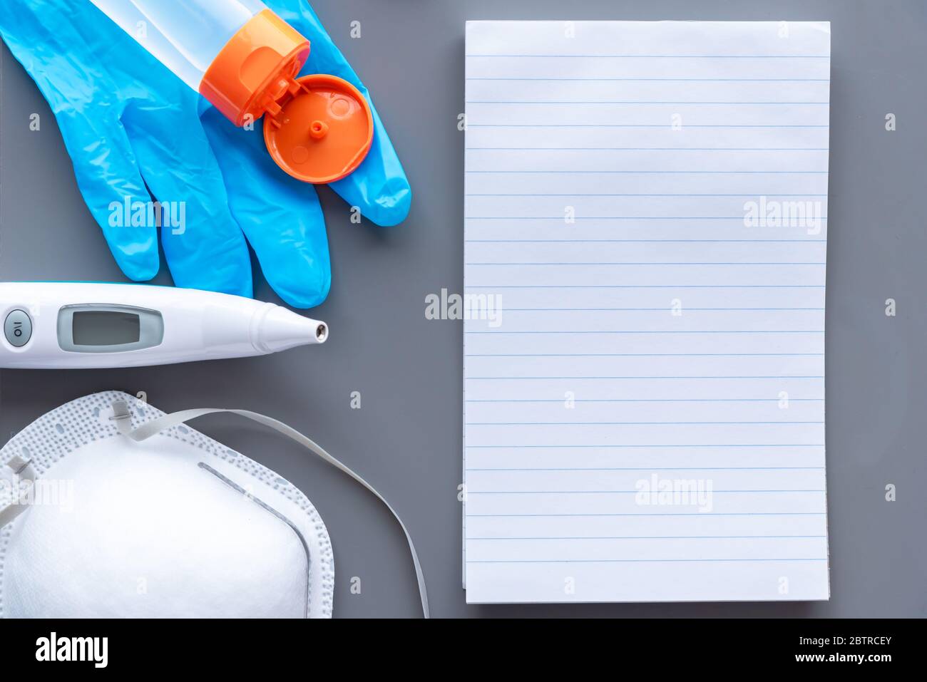Lined note pad paper, medical N95 mask, digital thermometer, surgical ...