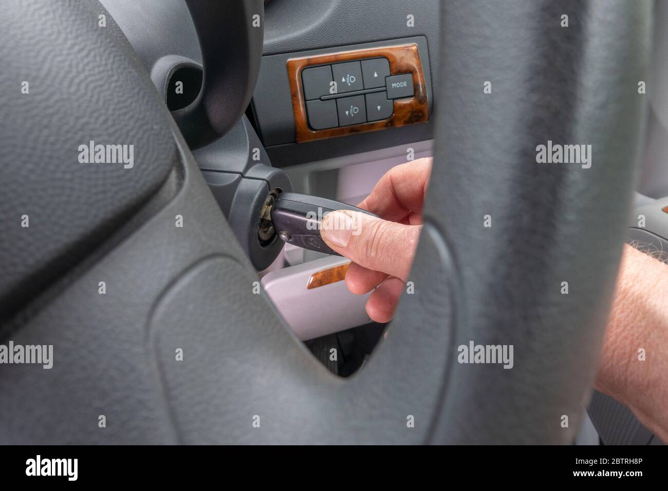 Closeup POV shot through the steering wheel of a vehicle, to a man’s ...