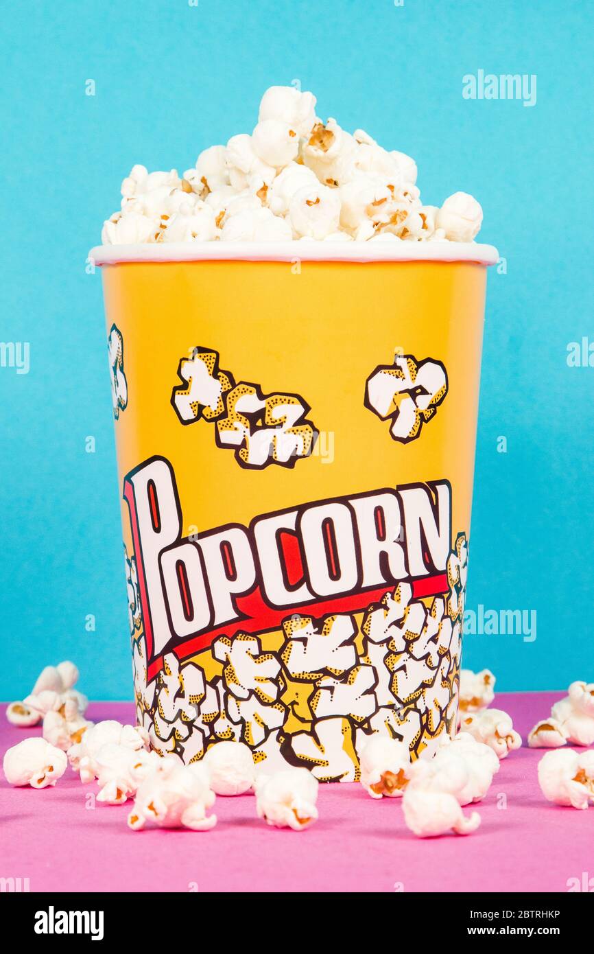 Yellow box of fresh popcorns on a pink and blue background Stock Photo ...